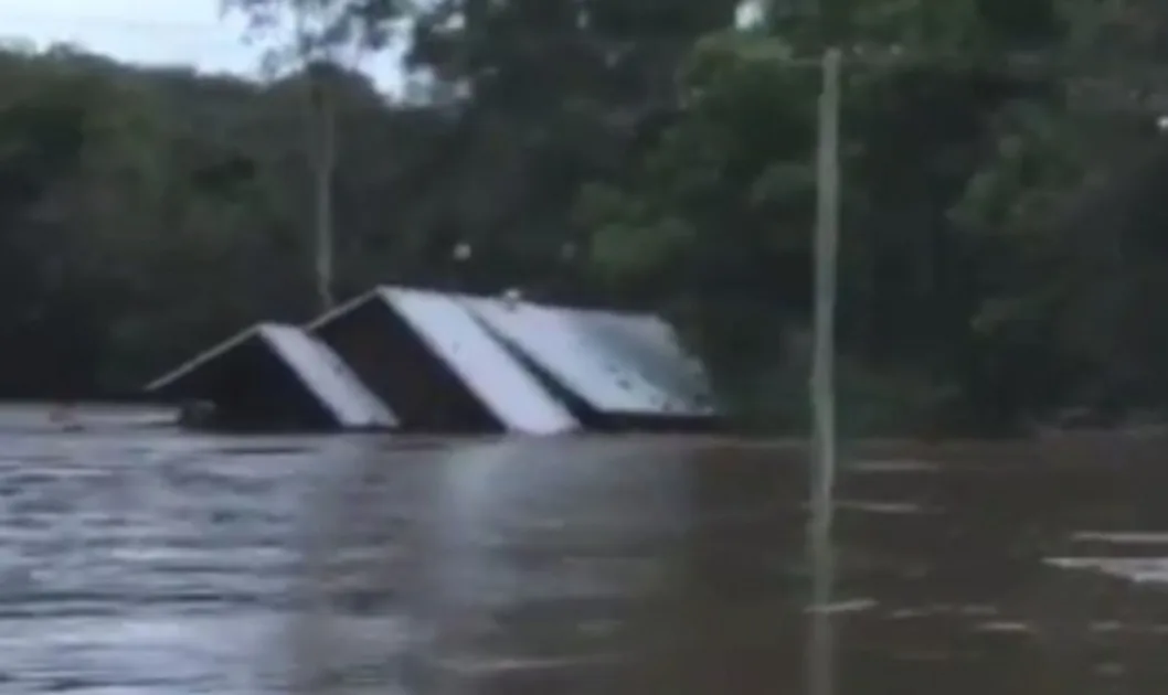 Family rescued from roof of house swept away in flood minutes later ...