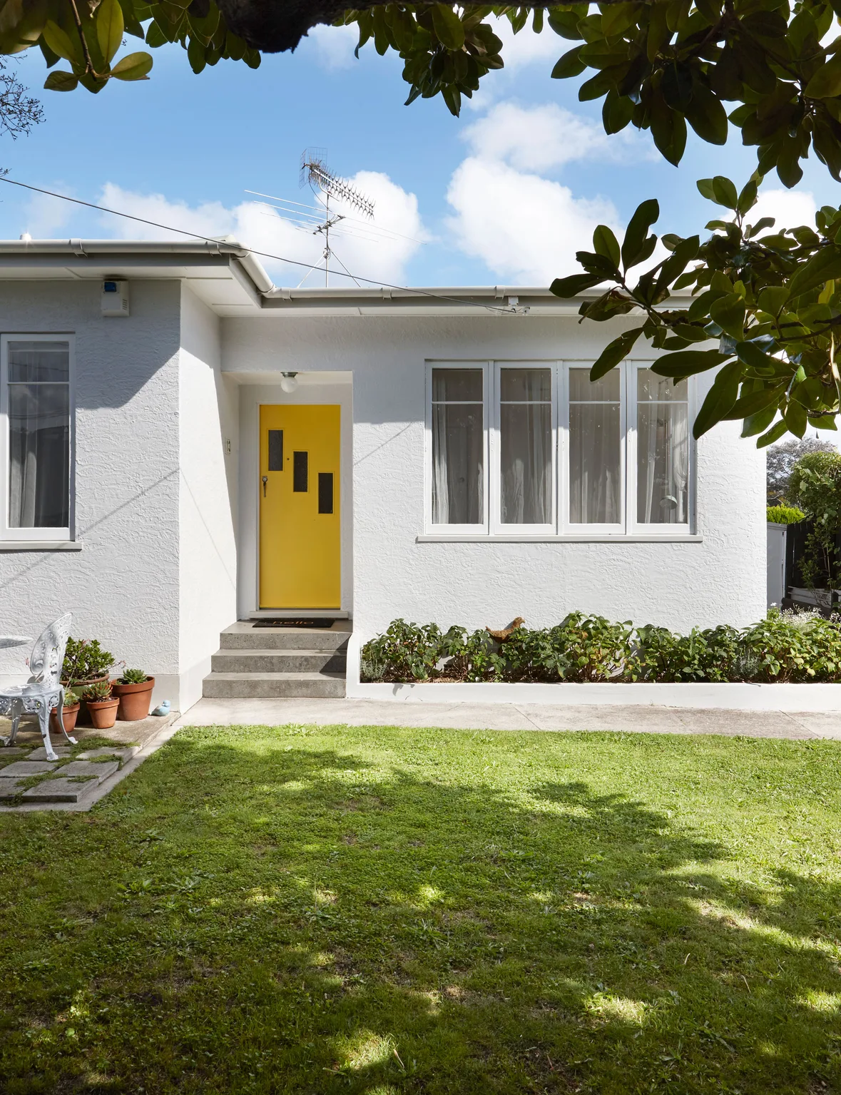 A concrete cottage in Auckland is softened with mid-century vibes