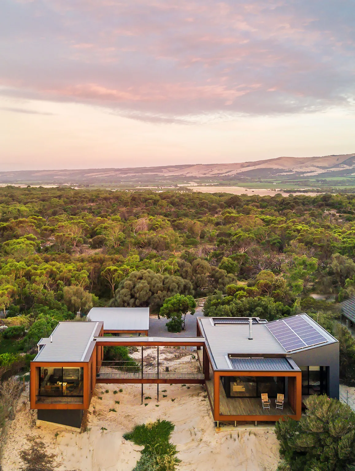 Red-steel beach house inspired by shipwrecks