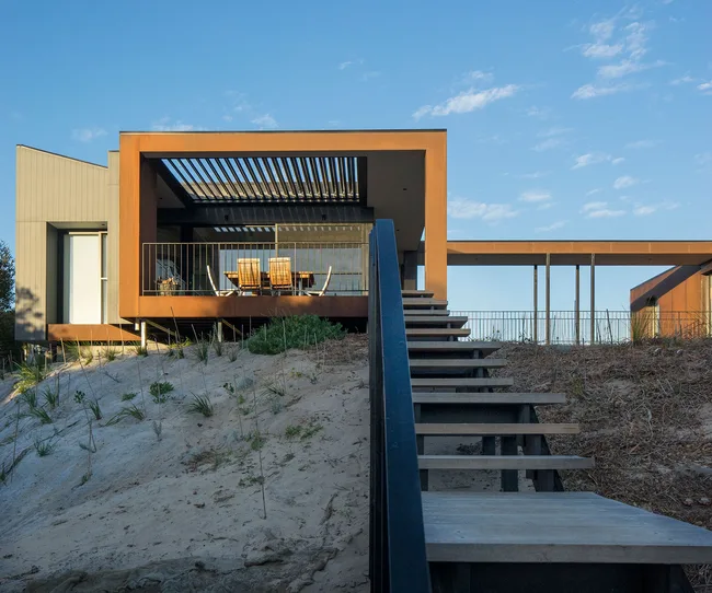 Red-steel beach house inspired by shipwrecks